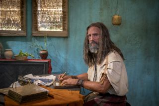 Nephi sitting at a table with the records